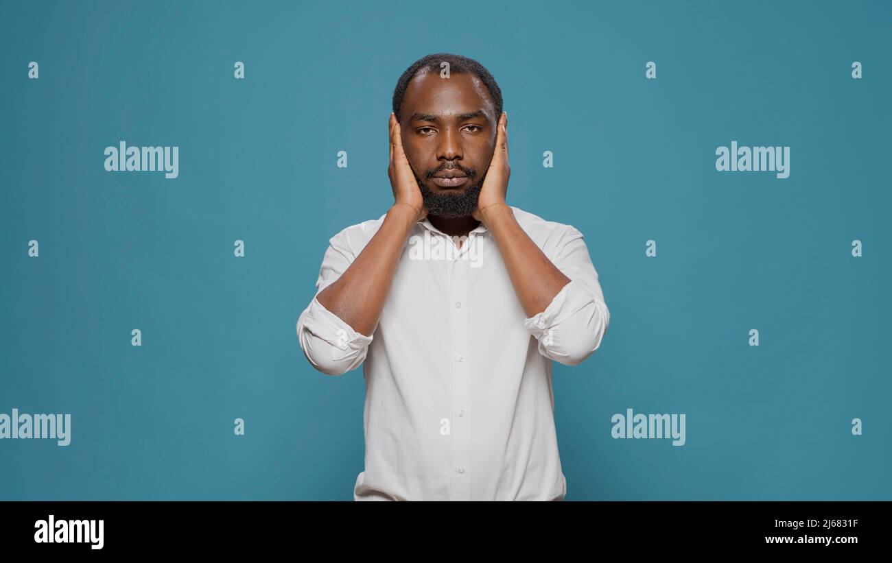 African american man doing three wise monkeys symbol, covering eyes ...