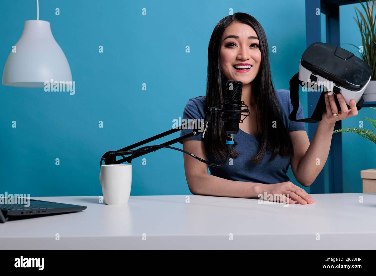 Asian content creator holding vitual reality headset advertising ...