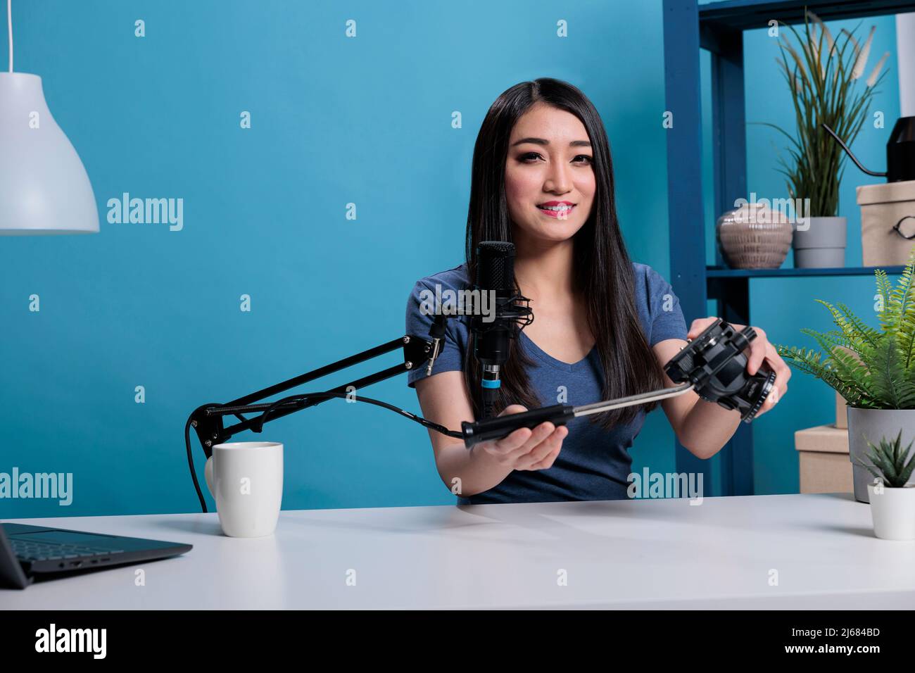 Asian content creator holding professional tripod advertising vlogging ...