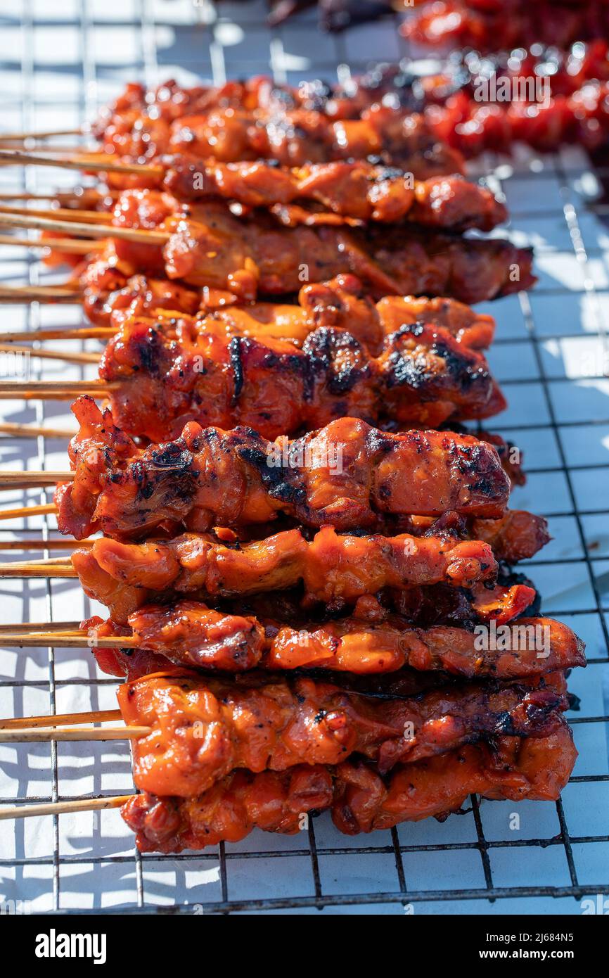 Thai street vendor sells grilled chicken meat at street food market in ...
