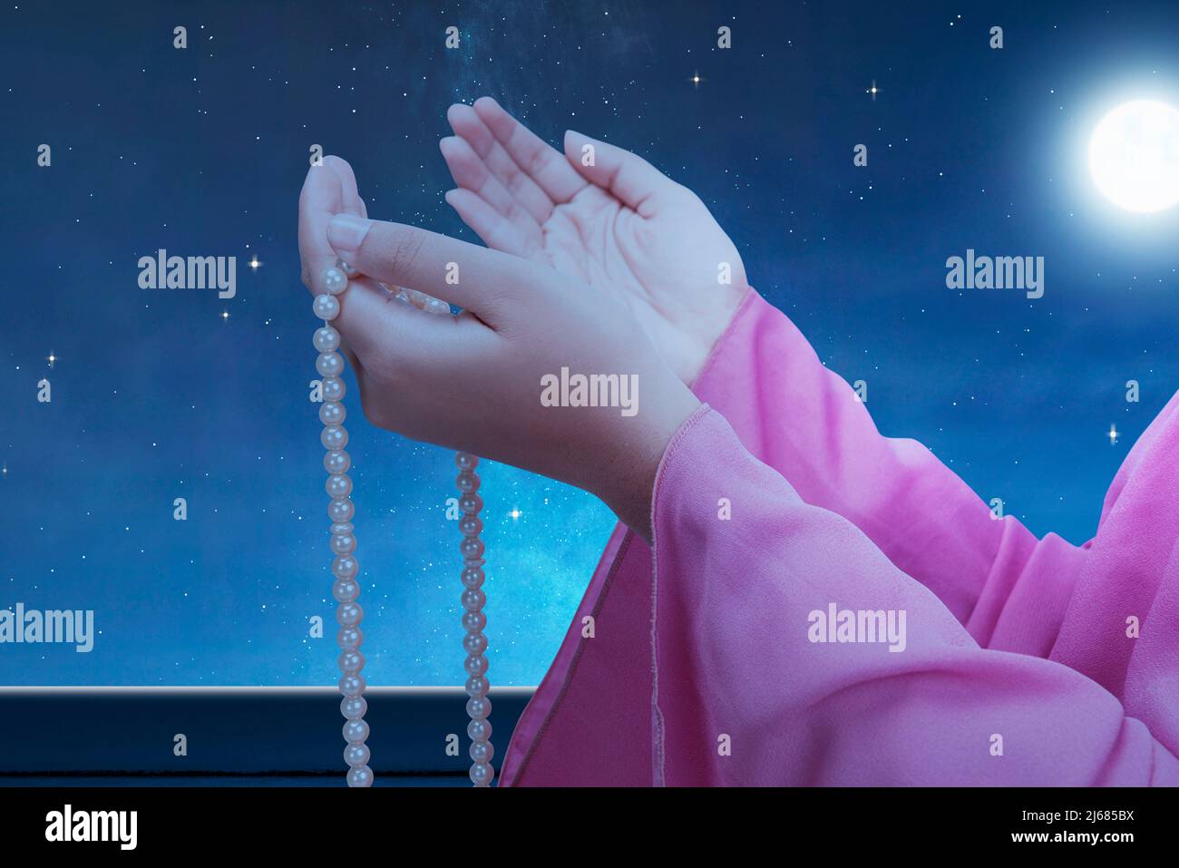 Muslim woman praying with prayer beads on her hands with the night ...