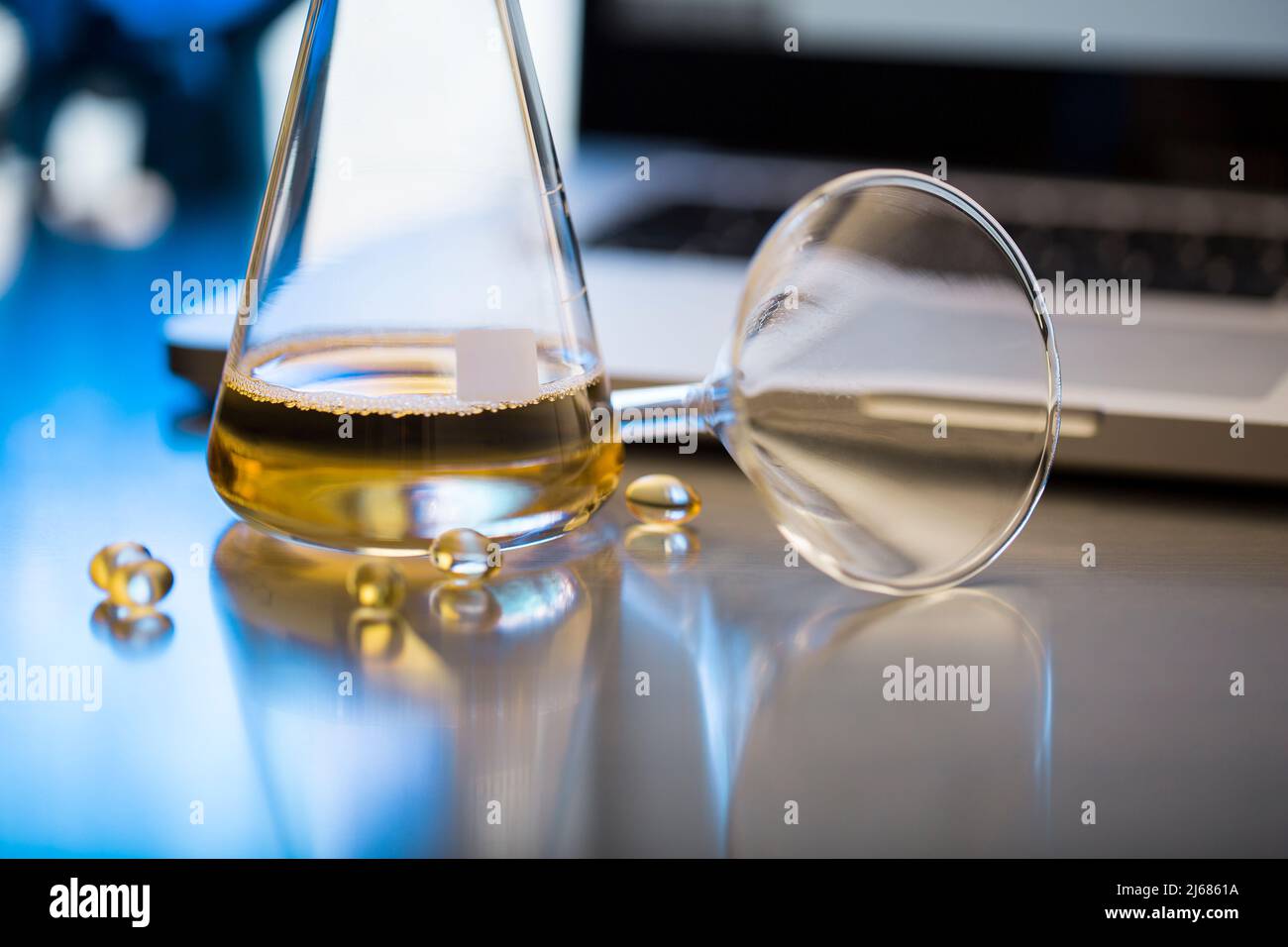 Conical flask containing a golden liquid medicine with Soft capsules ...