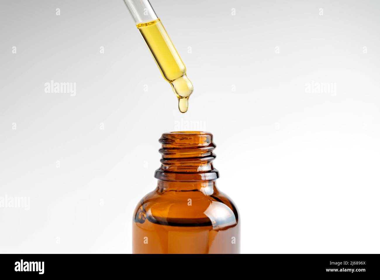 Pipette with falling drop of oil. Dropper with lotion, essence, serum ...