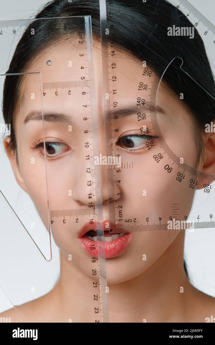 Do facial plastic young woman with a ruler Stock Photo - Alamy