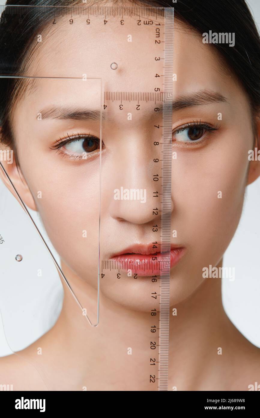 Do facial plastic young woman with a ruler Stock Photo - Alamy