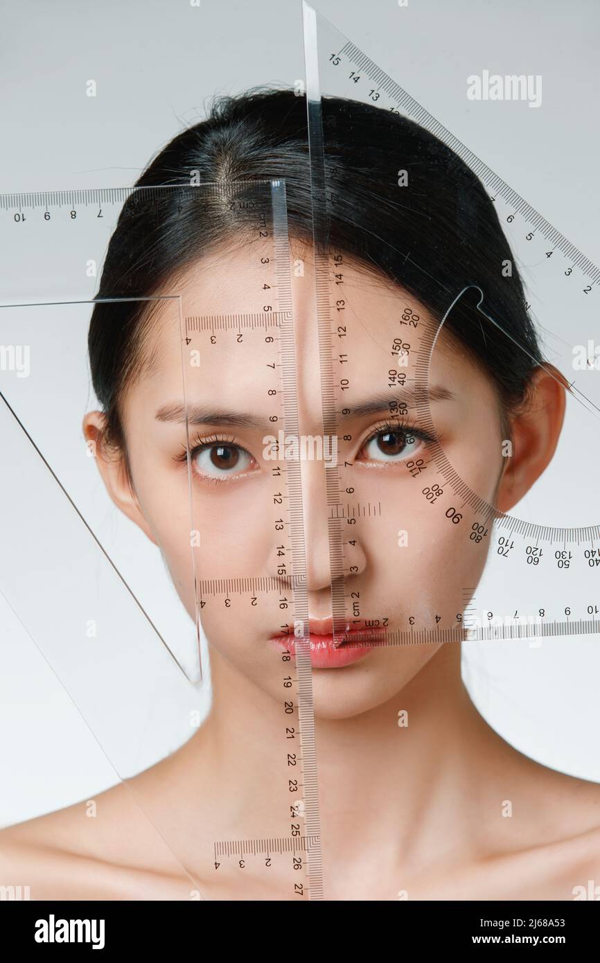 Do facial plastic young woman with a ruler Stock Photo - Alamy