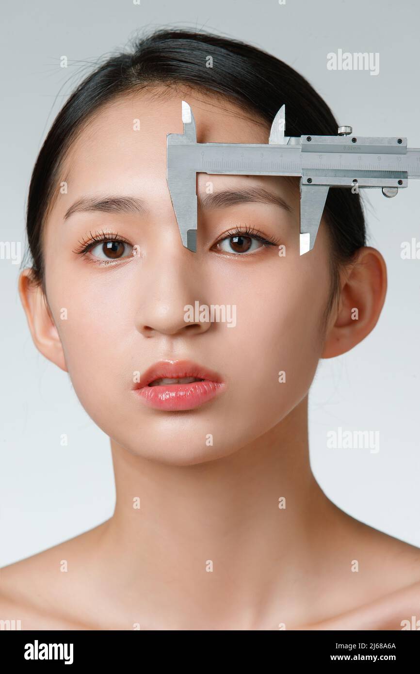 Plastic surgeon young woman face is measured with a caliper Stock Photo ...