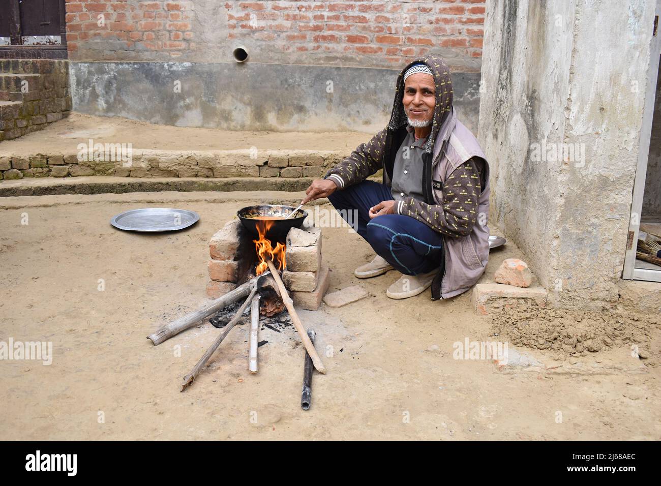 INDIA, UTTAR PRADESH, December 2021, A Rural Man cooking a curry on ...
