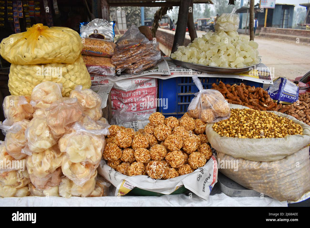 Sweets and Snacks for sale on a thela at village street, Laddu, Chana ...