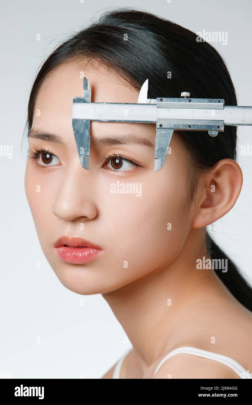 Plastic surgeon young woman face is measured with a caliper Stock Photo ...