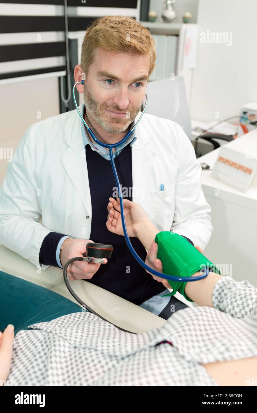 a doctor measures arm pressure Stock Photo - Alamy