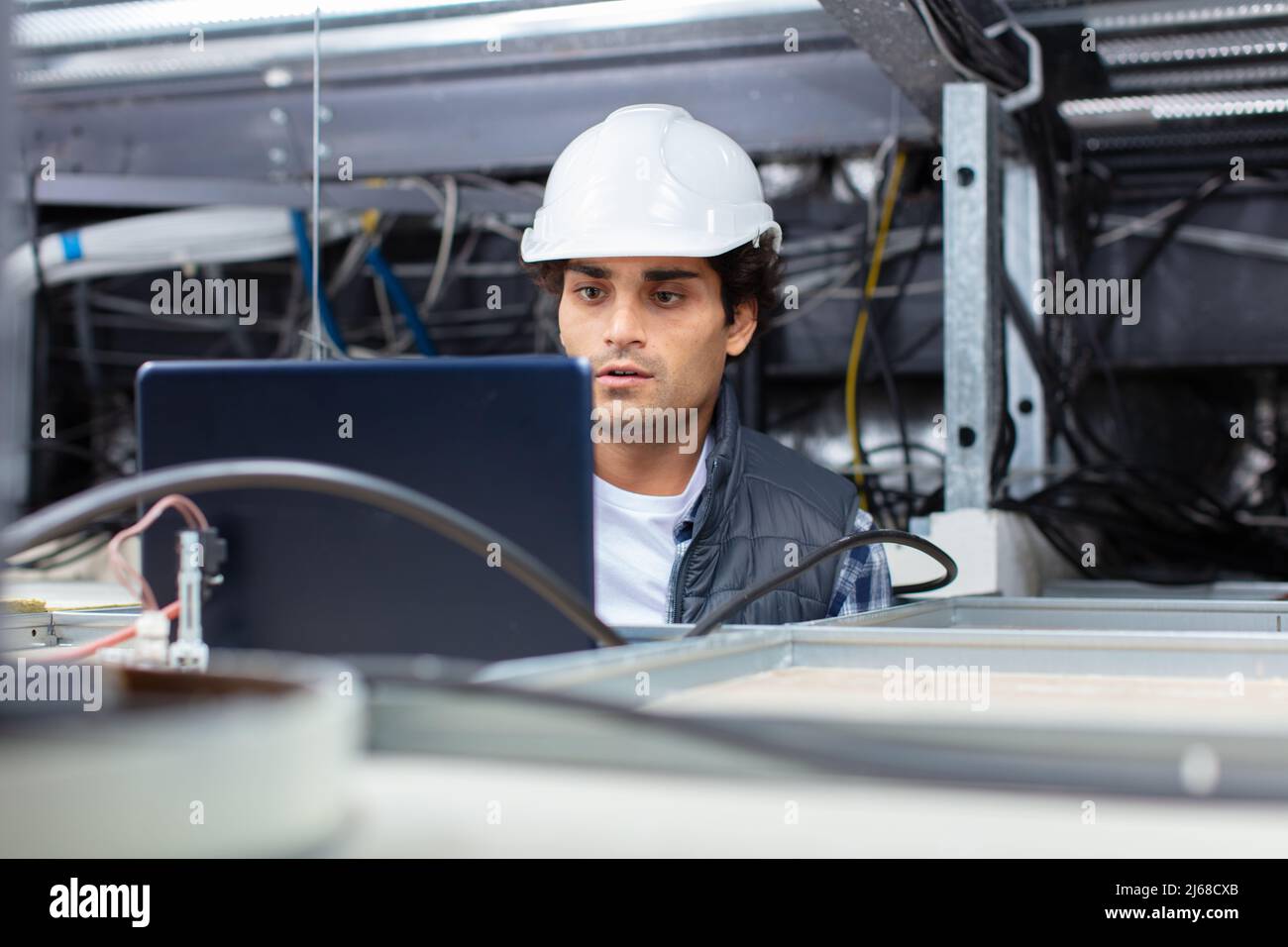 male contractor using laptop in roofspace Stock Photo - Alamy