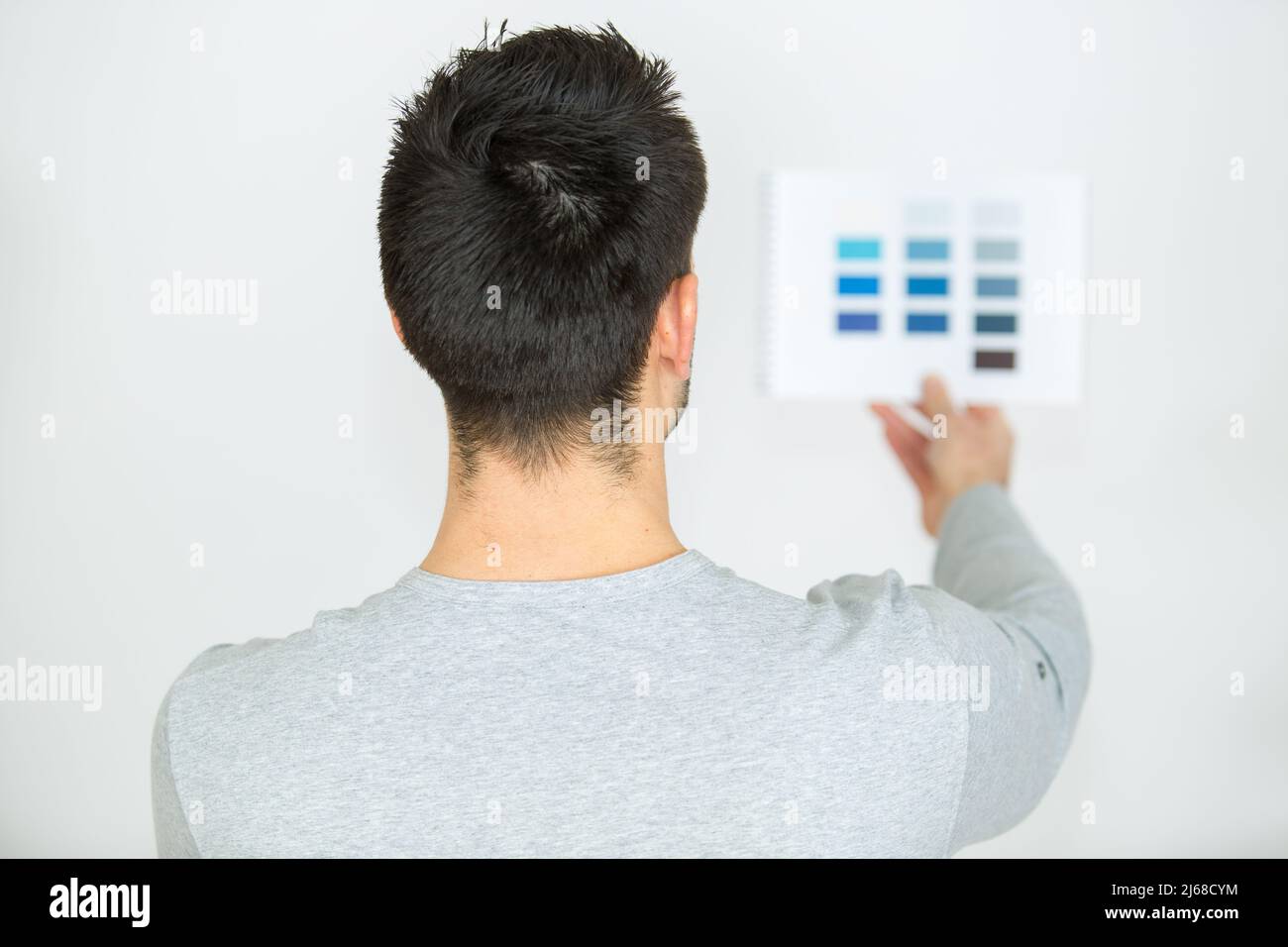 man looking at best color choice for wall Stock Photo - Alamy