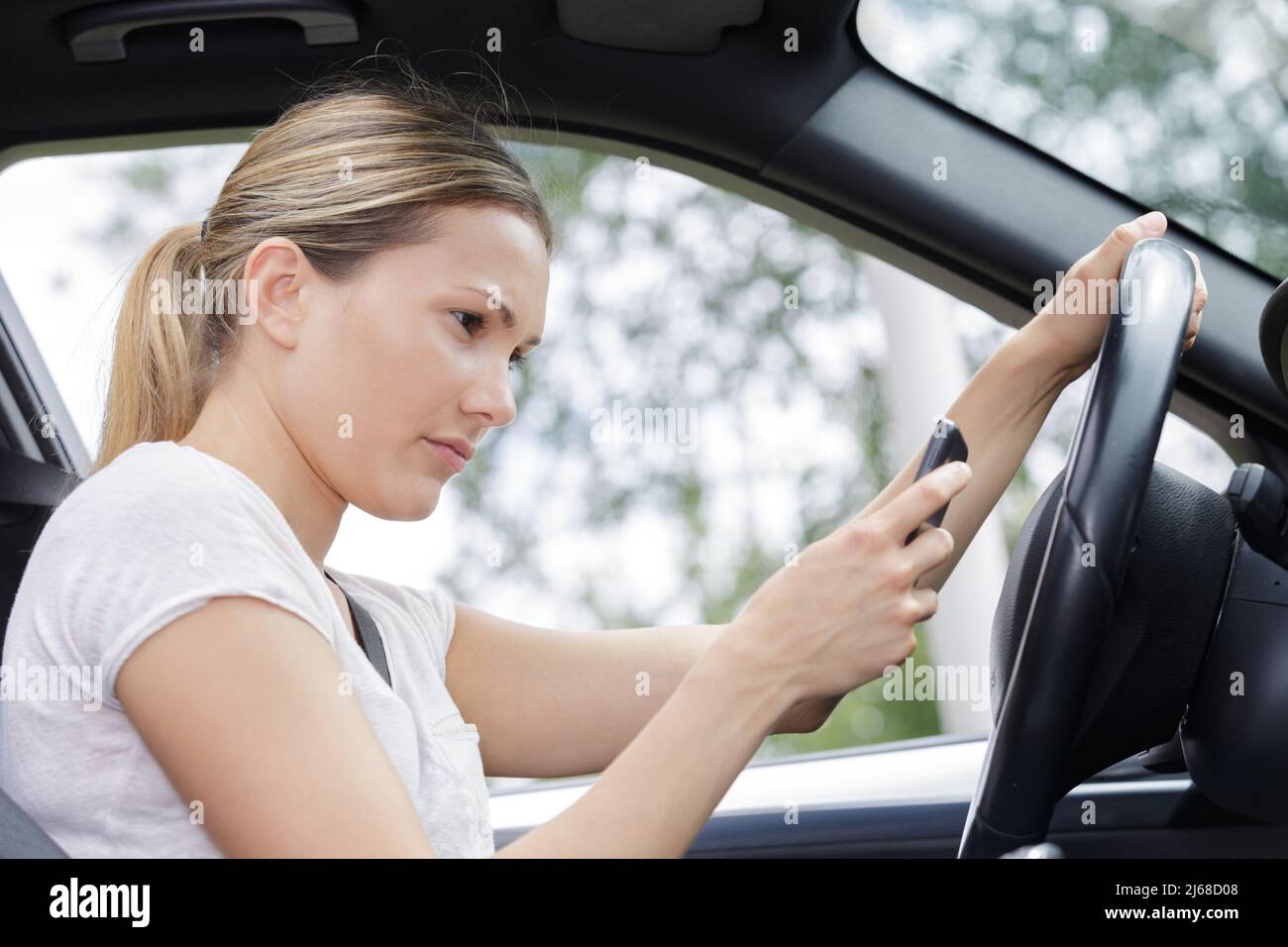 female driver texting while driving Stock Photo - Alamy