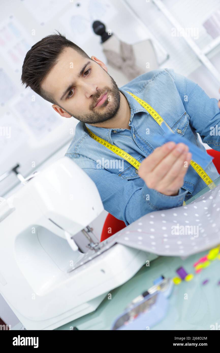male tailor using sewing machine holding zip Stock Photo - Alamy