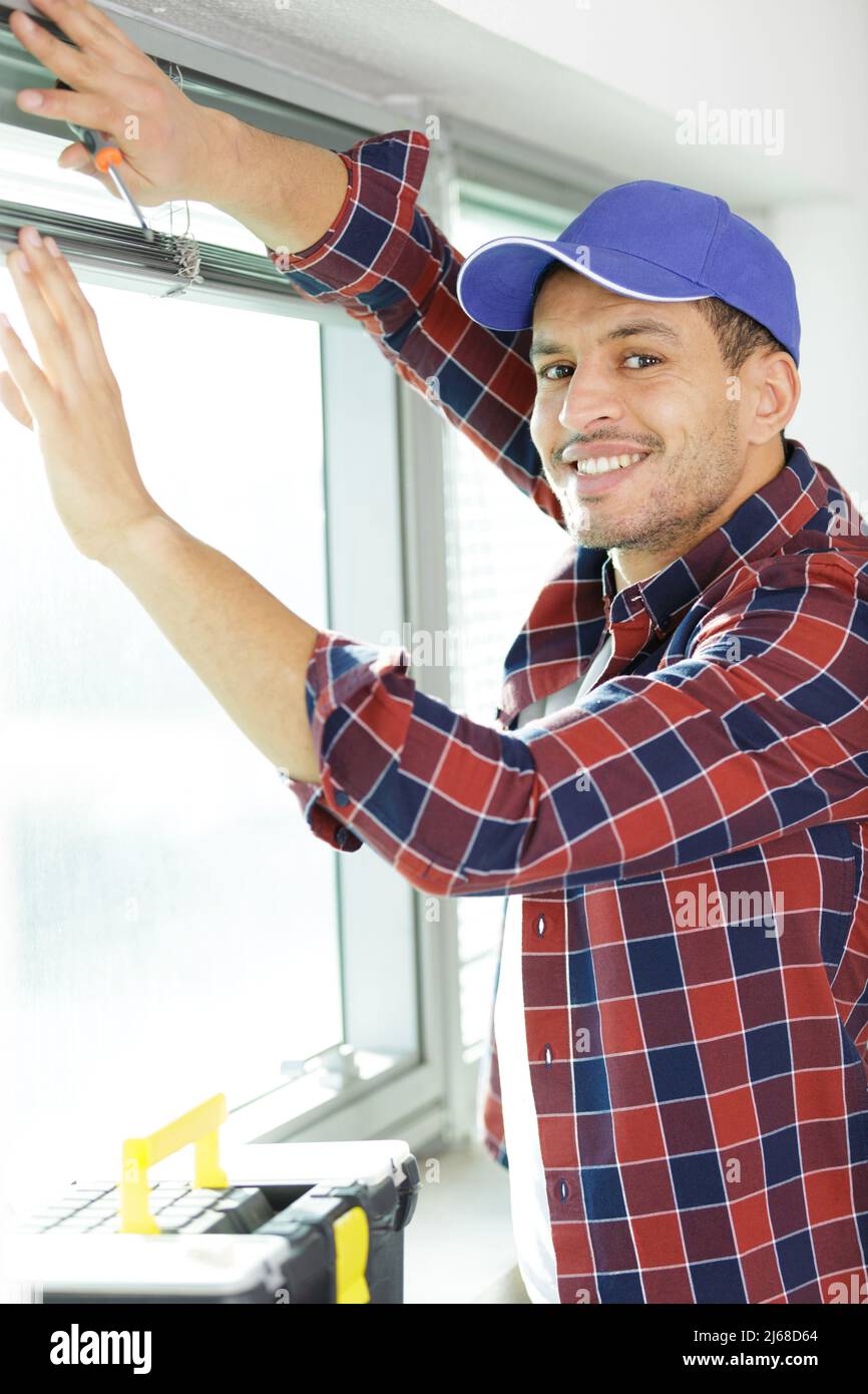 man is installing window blinds Stock Photo - Alamy