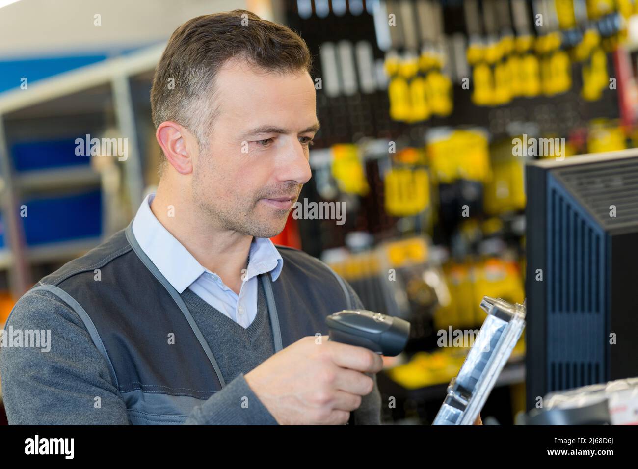 male shop assistant scanning product in hardware store Stock Photo - Alamy
