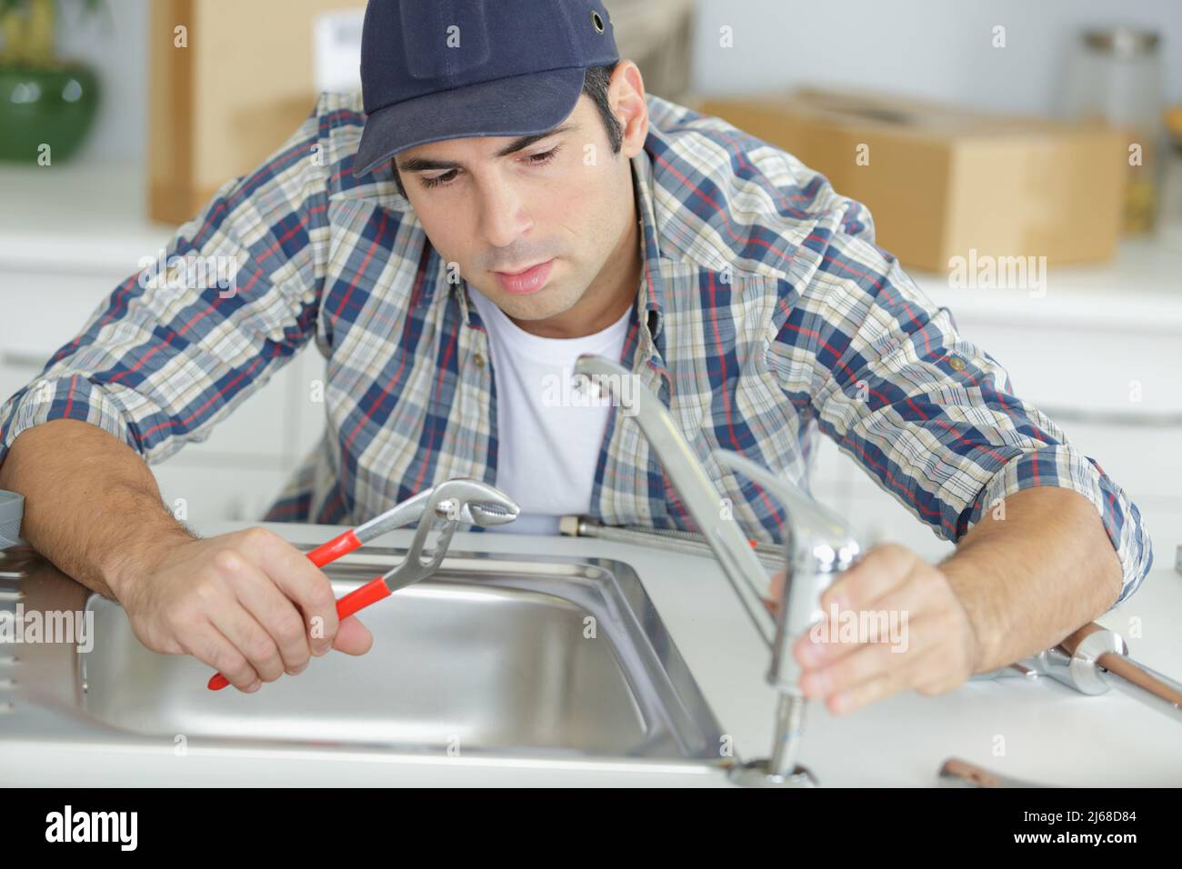 man fixing tap in the kitchen at home Stock Photo - Alamy