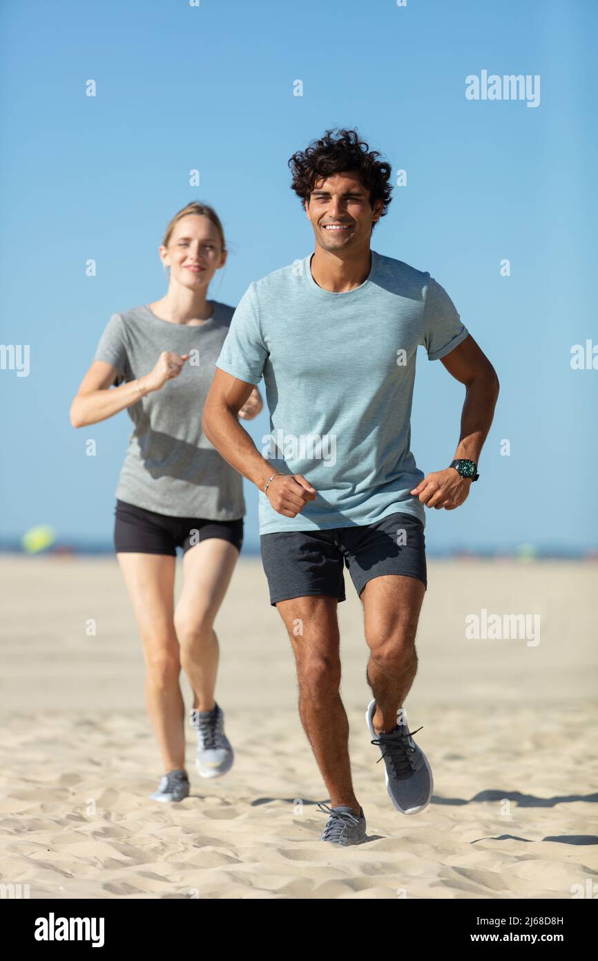 happy couple running together beside the water Stock Photo - Alamy
