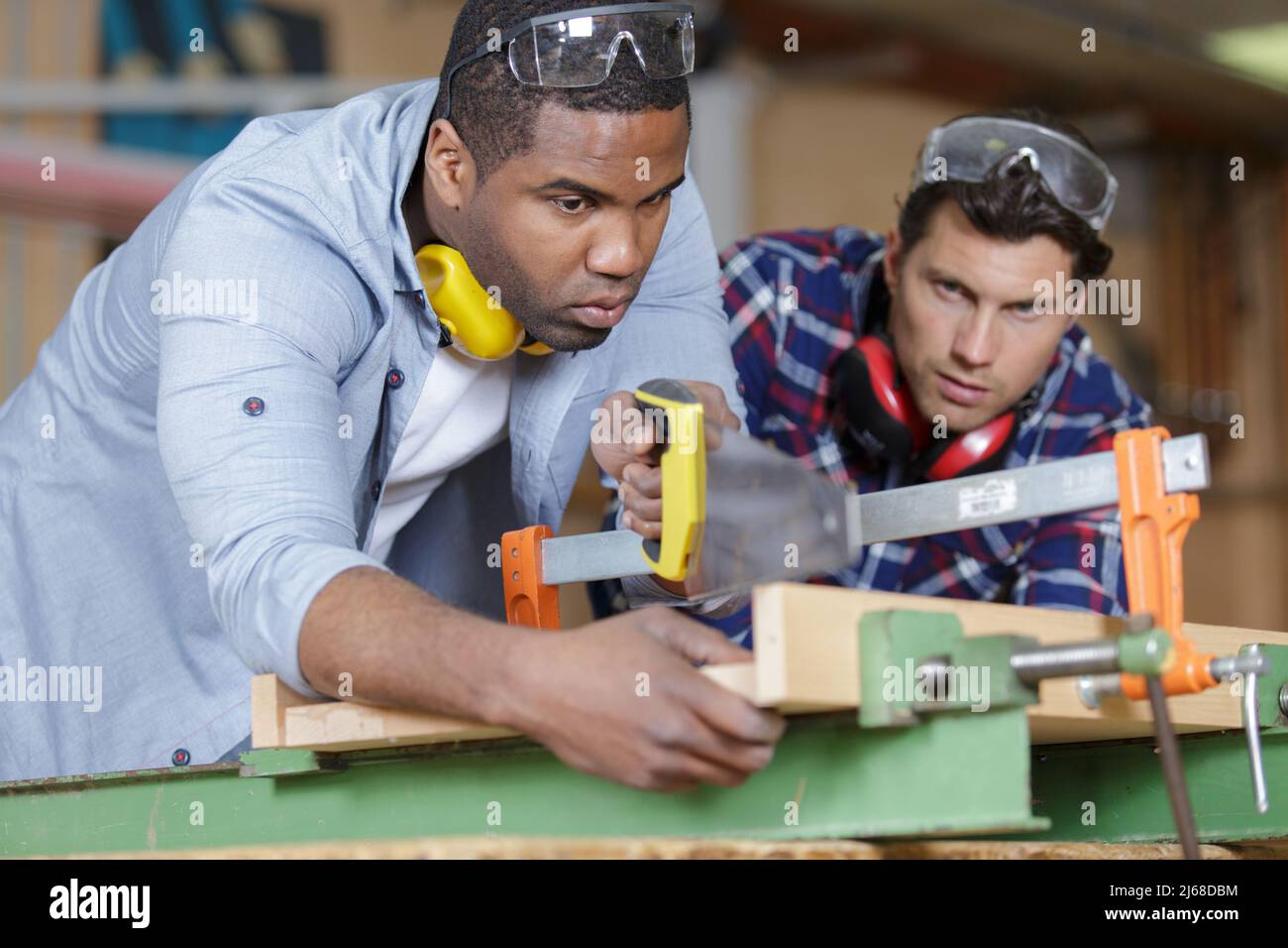 carpenter and apprentice working in studio Stock Photo - Alamy