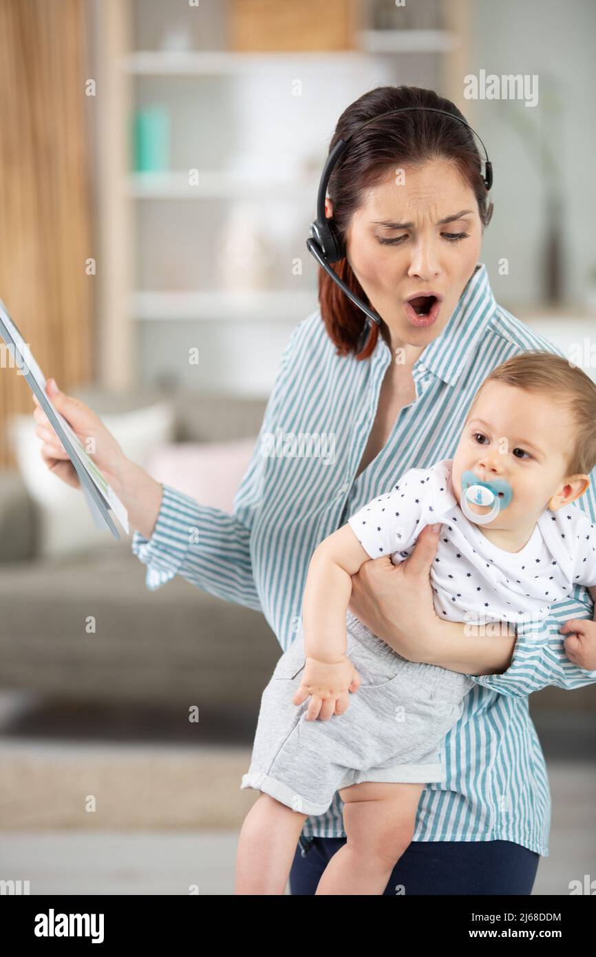 career mom suffering while nursing a child Stock Photo - Alamy