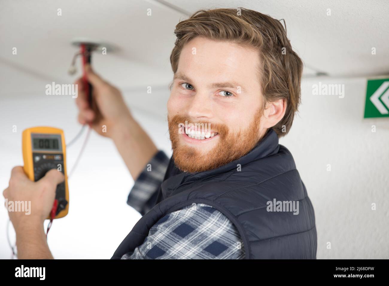 electrician using a multimeter to test spotlight connections Stock ...