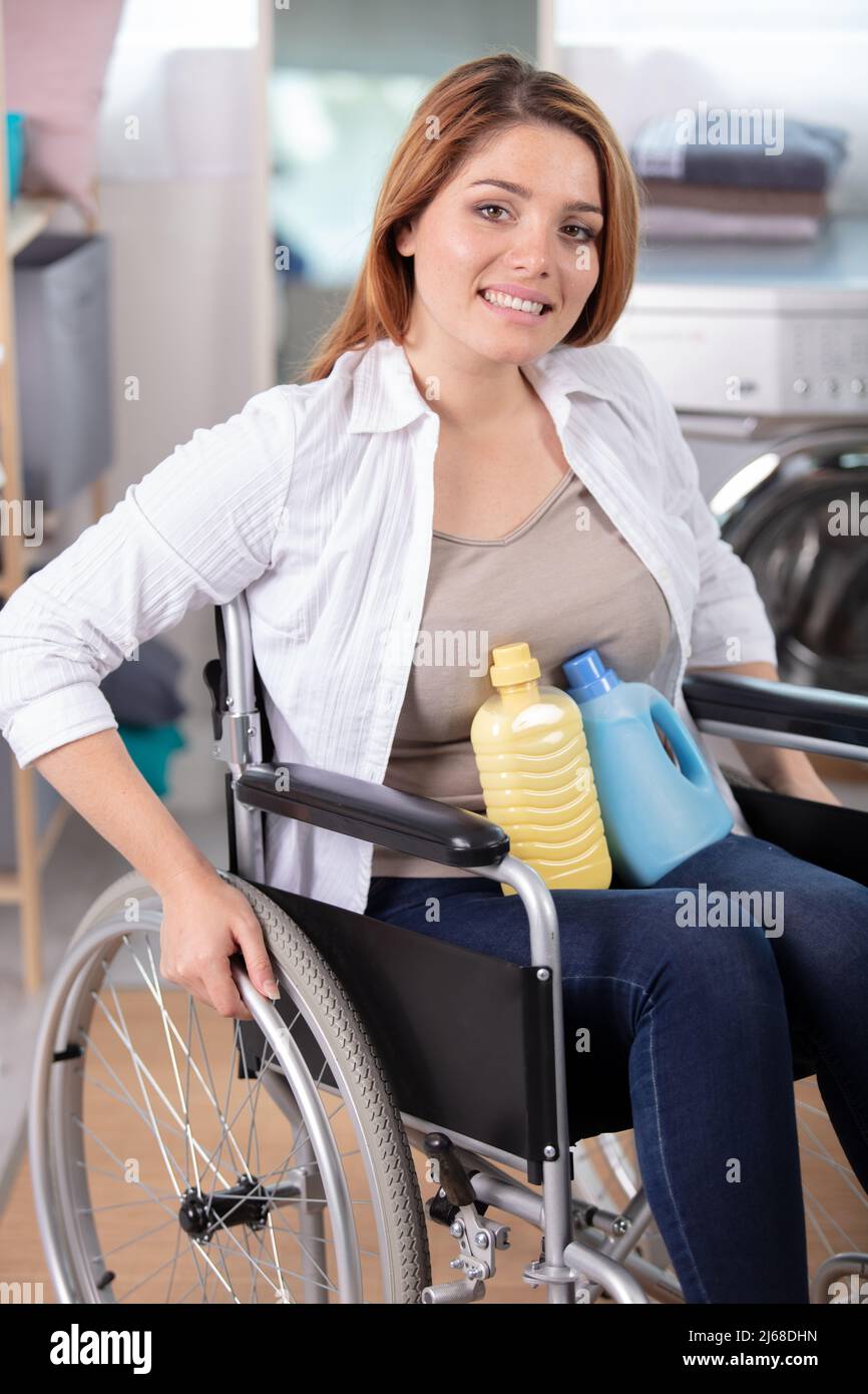 woman in wheelchair carrying laundry products Stock Photo - Alamy