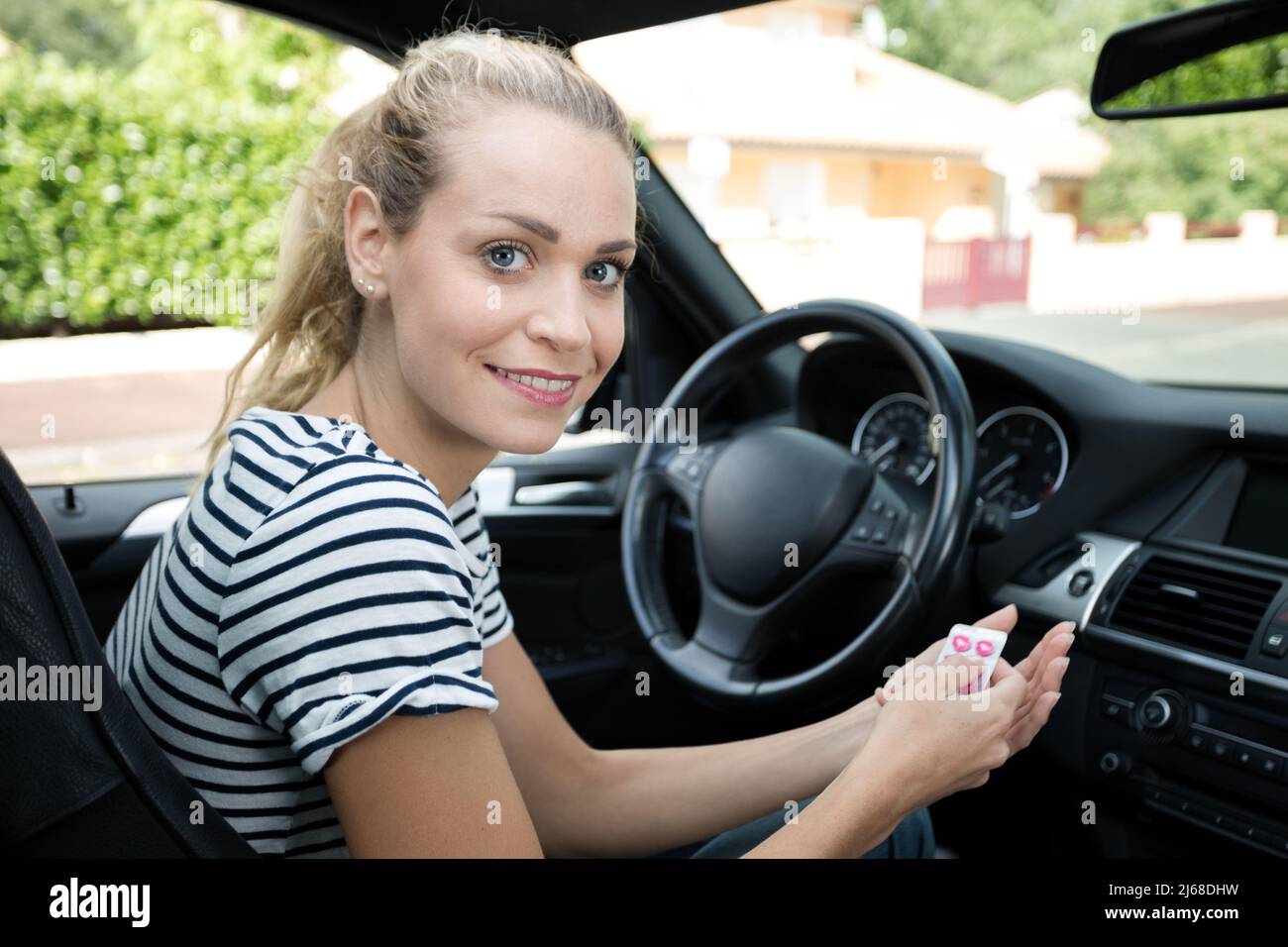 young woman taking pill while driving Stock Photo - Alamy