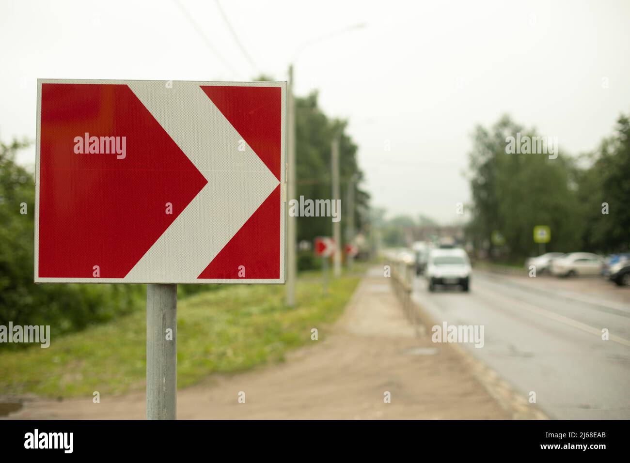Sign sharp turn. Red road sign. Arrow pointer on road. Infrastructure ...