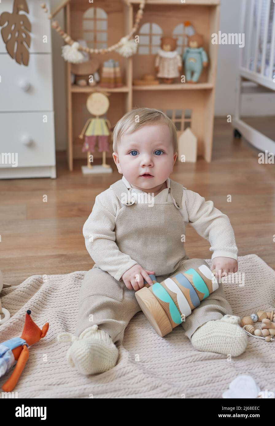 Wonderful baby boy with blue eyes. Child playing with toys in nursery ...