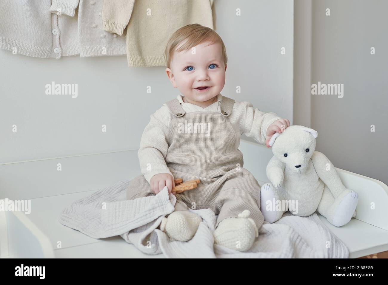 Wonderful baby boy with blue eyes. Child playing with toys in nursery ...