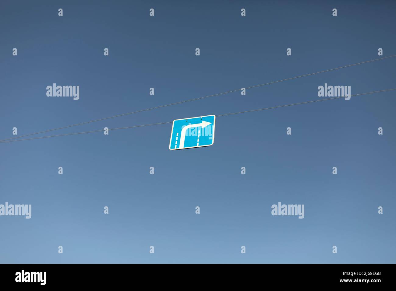 Right turn sign. Road sign over road. Blue sign with arrow against sky ...