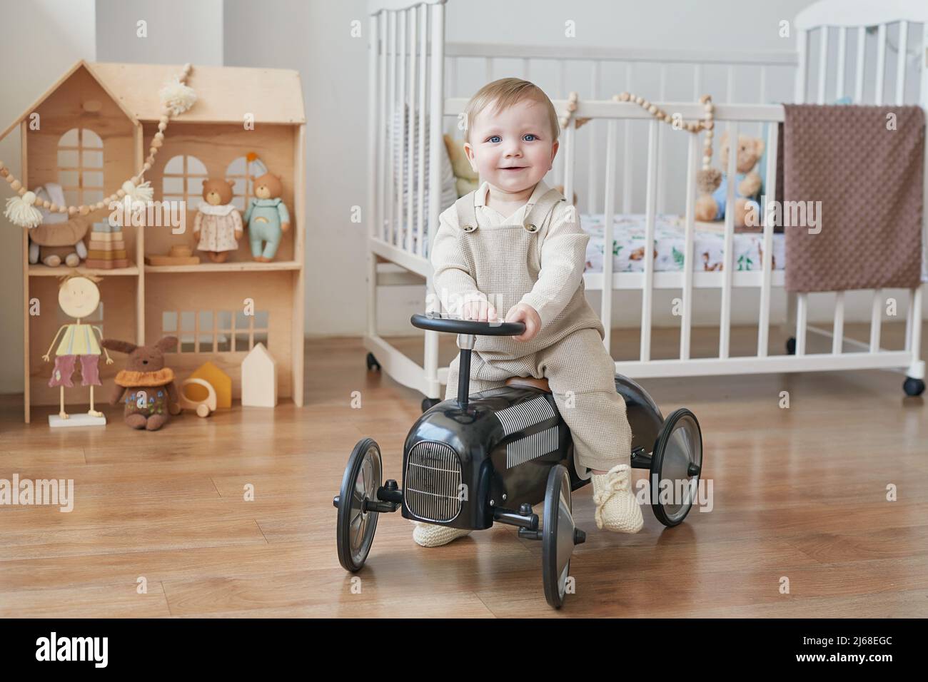 Wonderful baby boy with blue eyes. Child playing with car and toys in ...