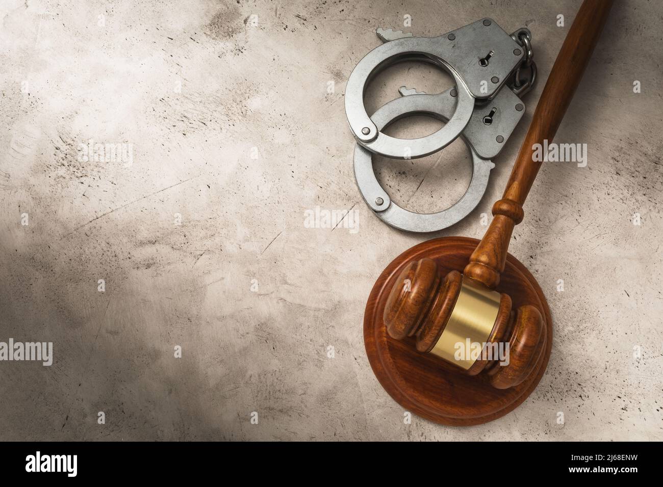 Wooden gavel of the judge and handcuffs on the right side on an ...