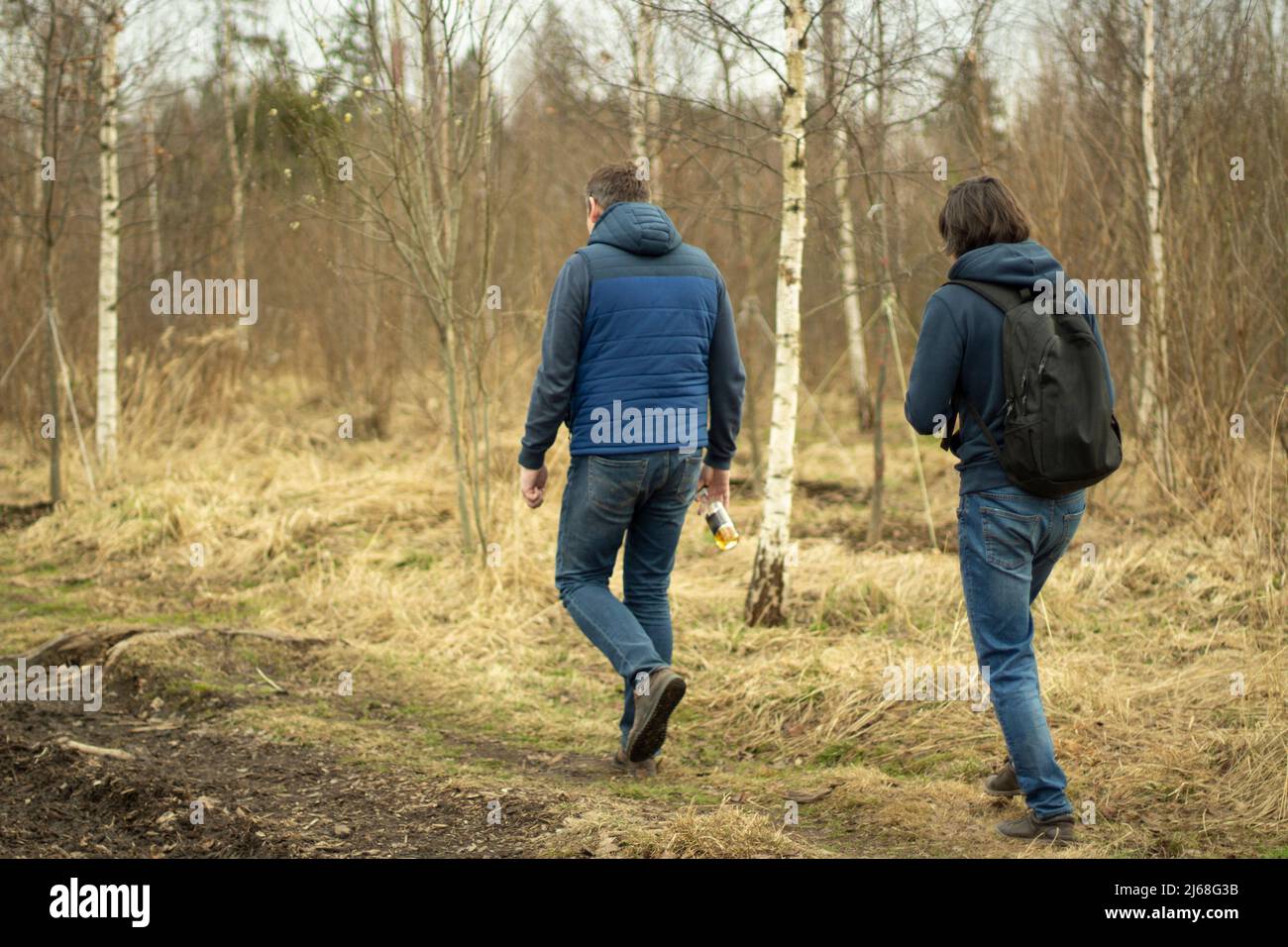 Guys walking in the park. Tourists walk along the trail. Men in blue ...