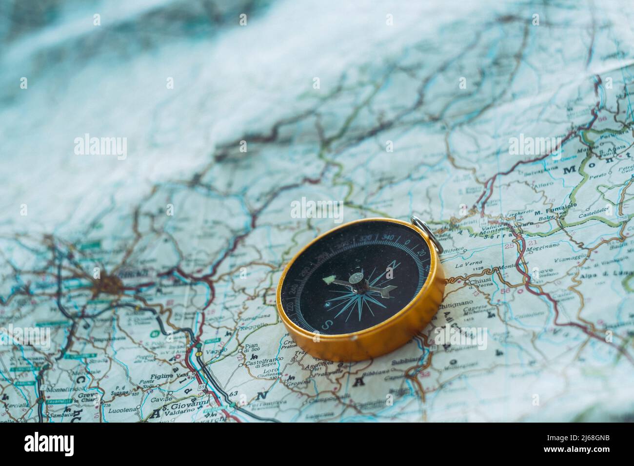 Close up of compass on paper map guide. Travel and adventure lifestyle ...