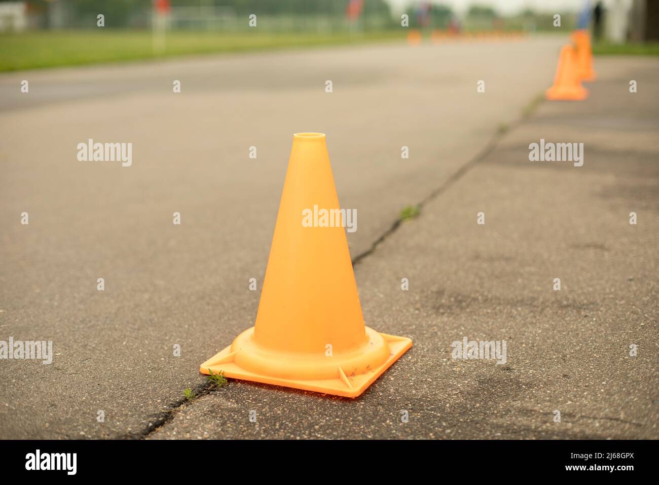 Orange cap on road. Warning sign. Direction limiter Stock Photo - Alamy