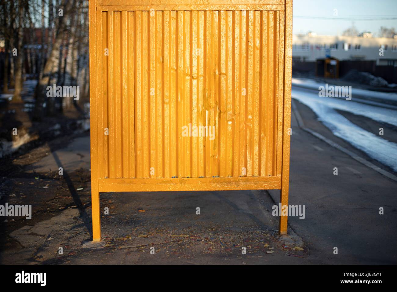 Yellow bus stop. Steel structure by road. Place of transport stop in ...