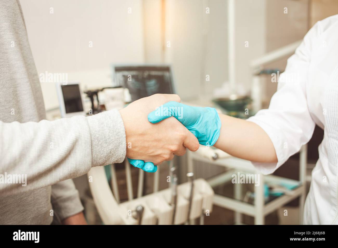 doctor and patient shake hands, happy and satisfied with cooperation ...