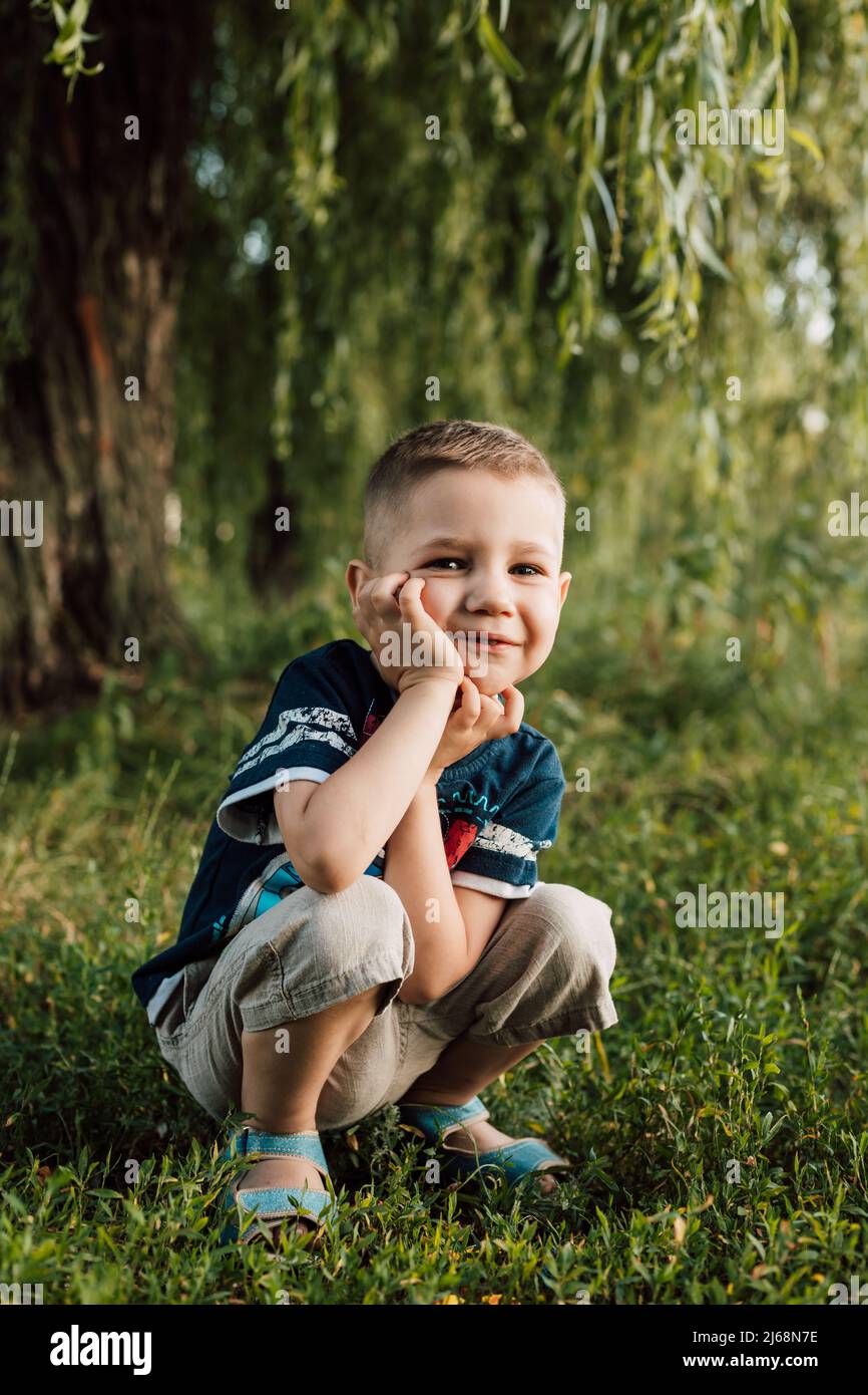 Boy crouched grass High Resolution Stock Photography and Images - Alamy