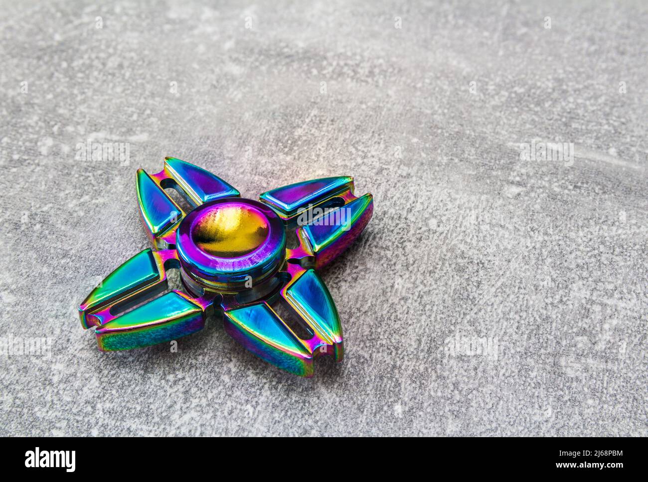 Star shaped stainless steel metalic fidget spinner on marble background ...