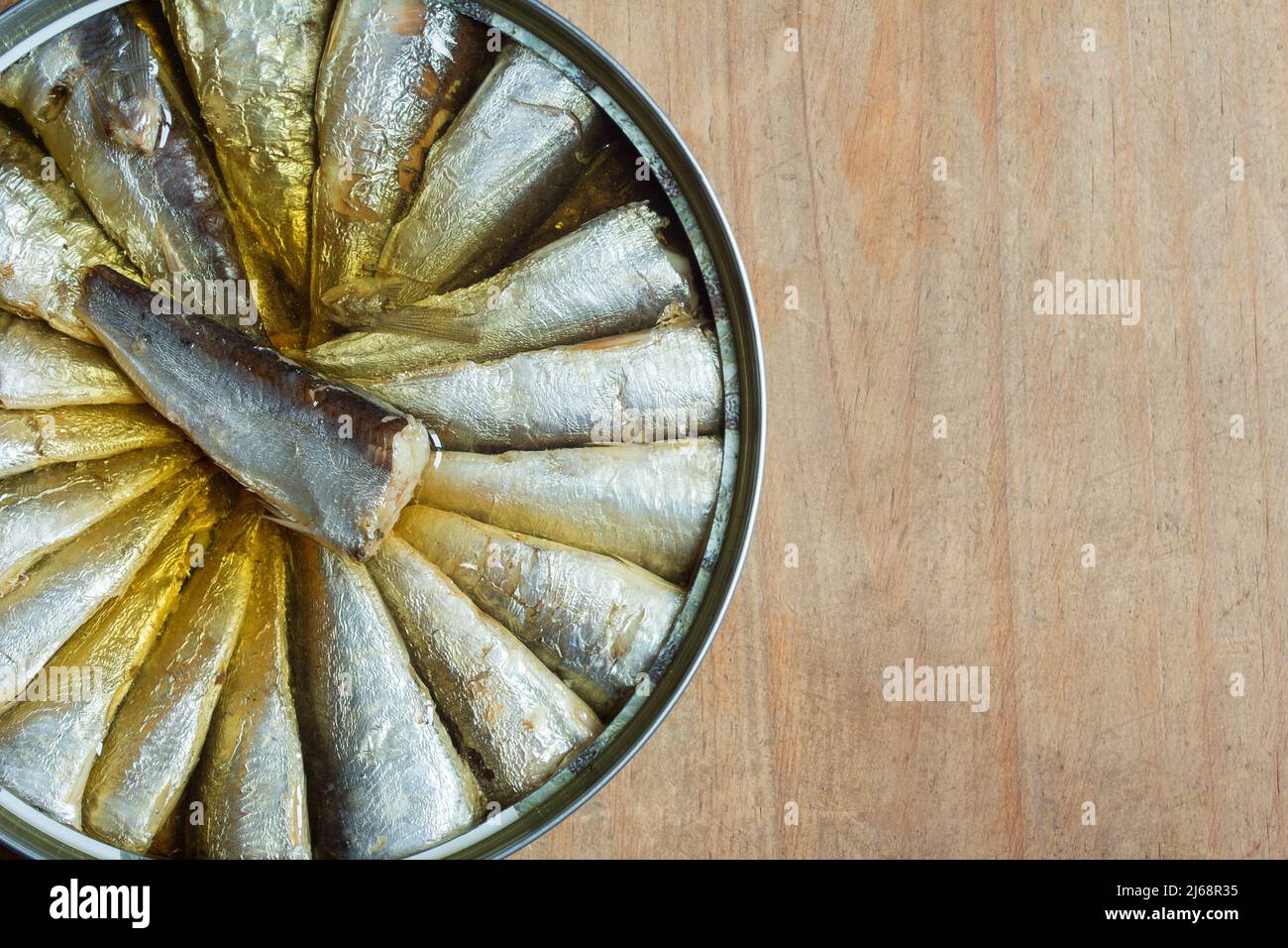 A close-up of a canned sardine on rustic weathered wood background with ...
