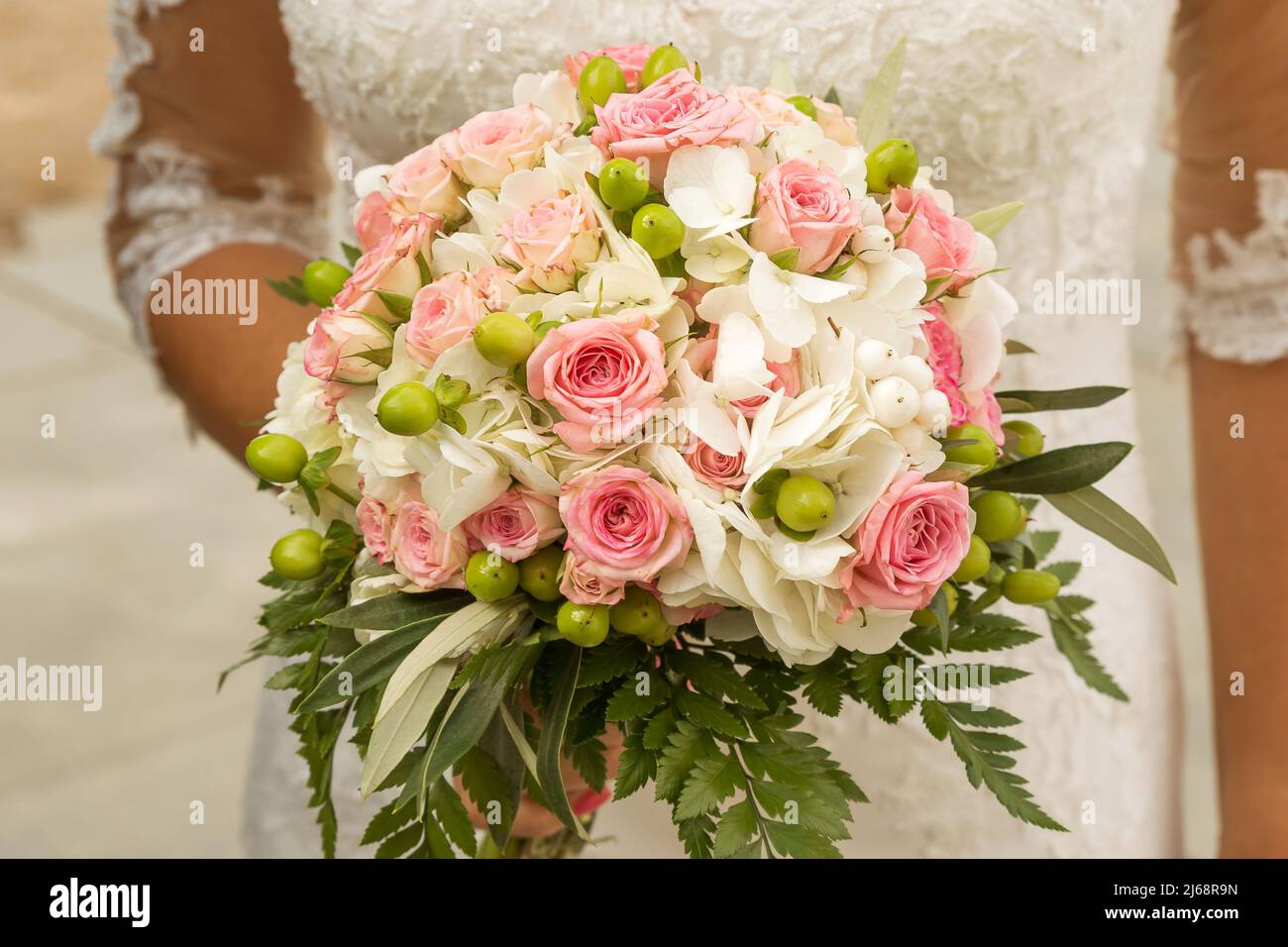 Pretty flower bouquet with roses shown by a bride on her wedding day ...