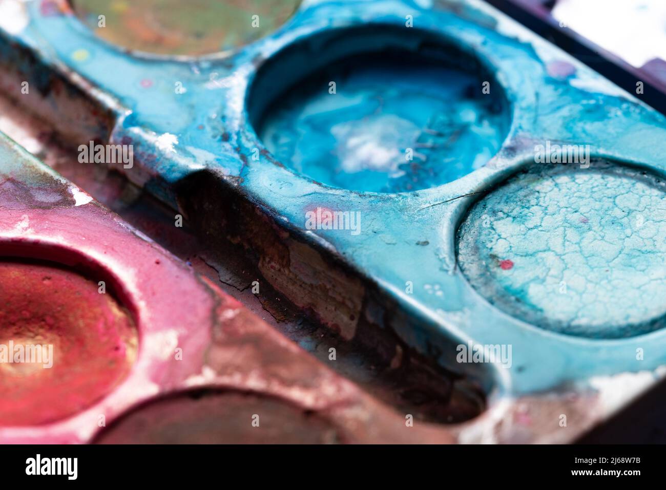 Blurry watercolor paints in close-up. Dirty paint packaging ...