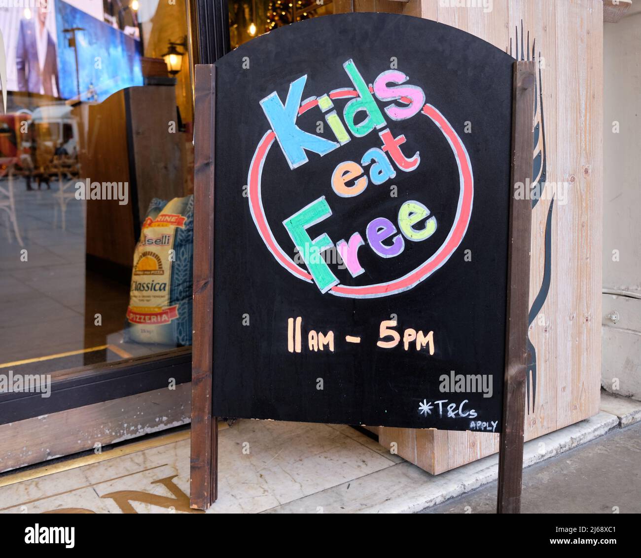 Kids eat free sign on blackboard at entrance of restaurant Stock Photo ...