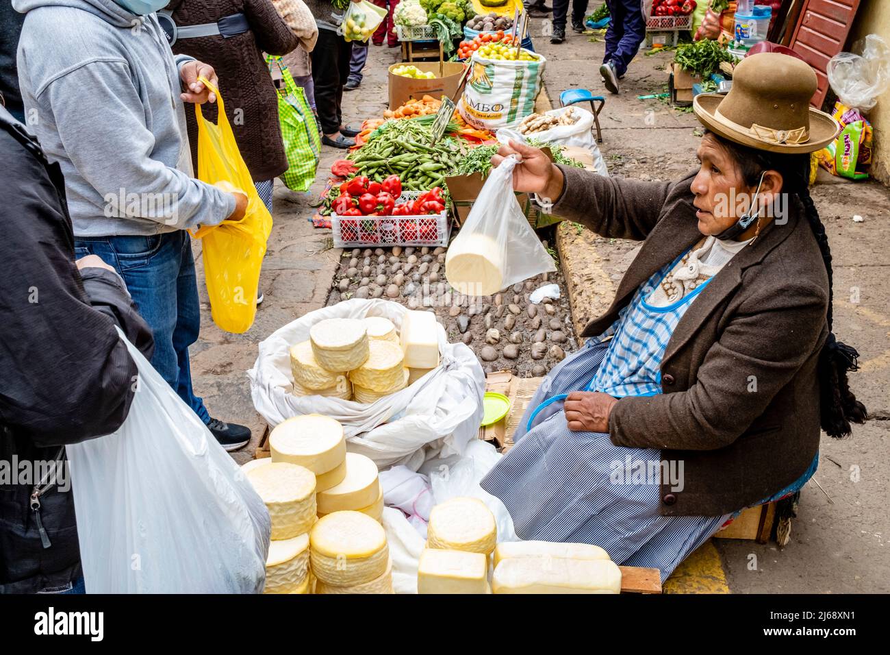 An Indigenous Woman Selling Fresh Cheese At A Street Market In Cusco ...