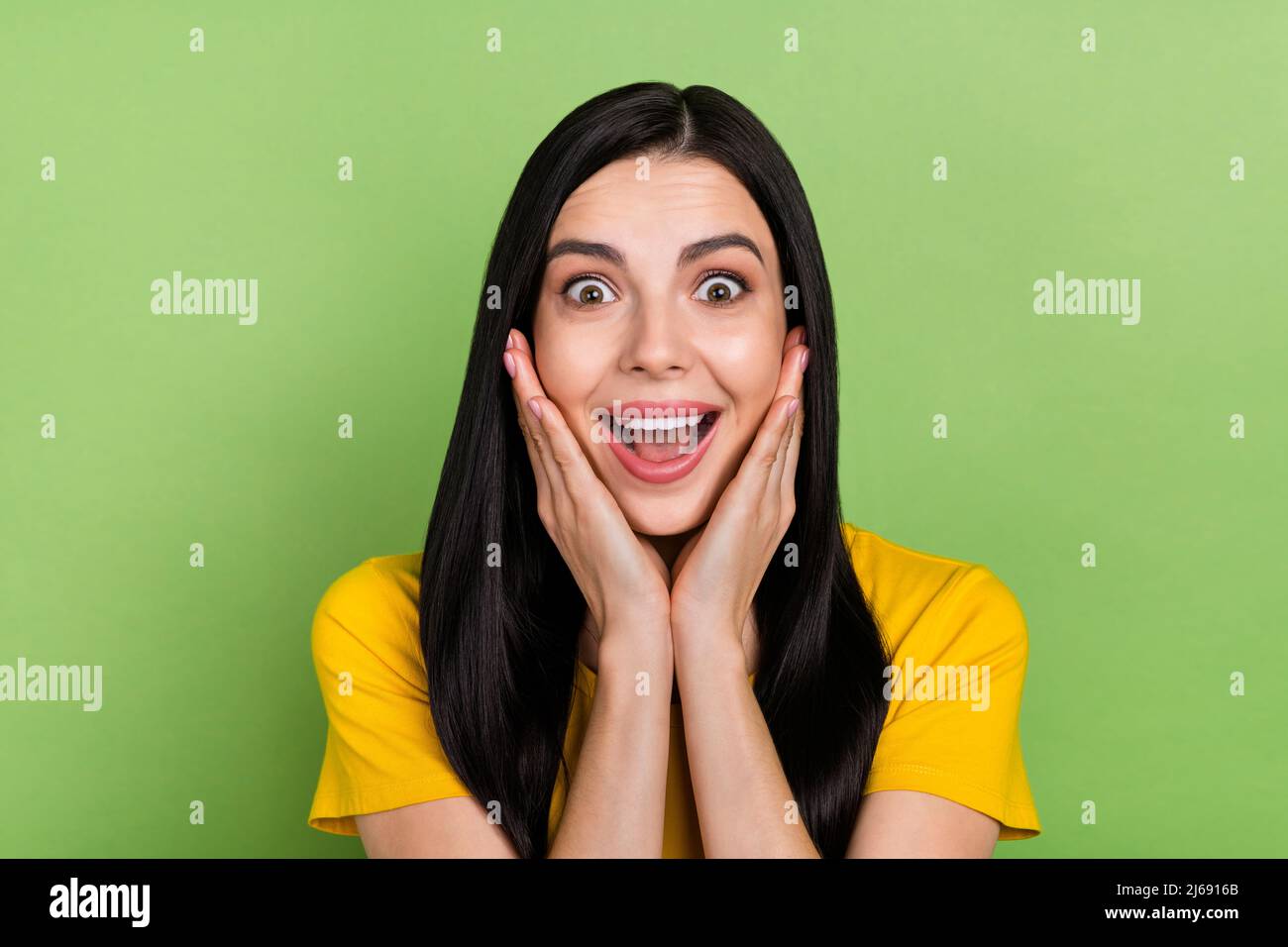 Photo of charming impressed lady dressed yellow t-shirt arms cheeks ...
