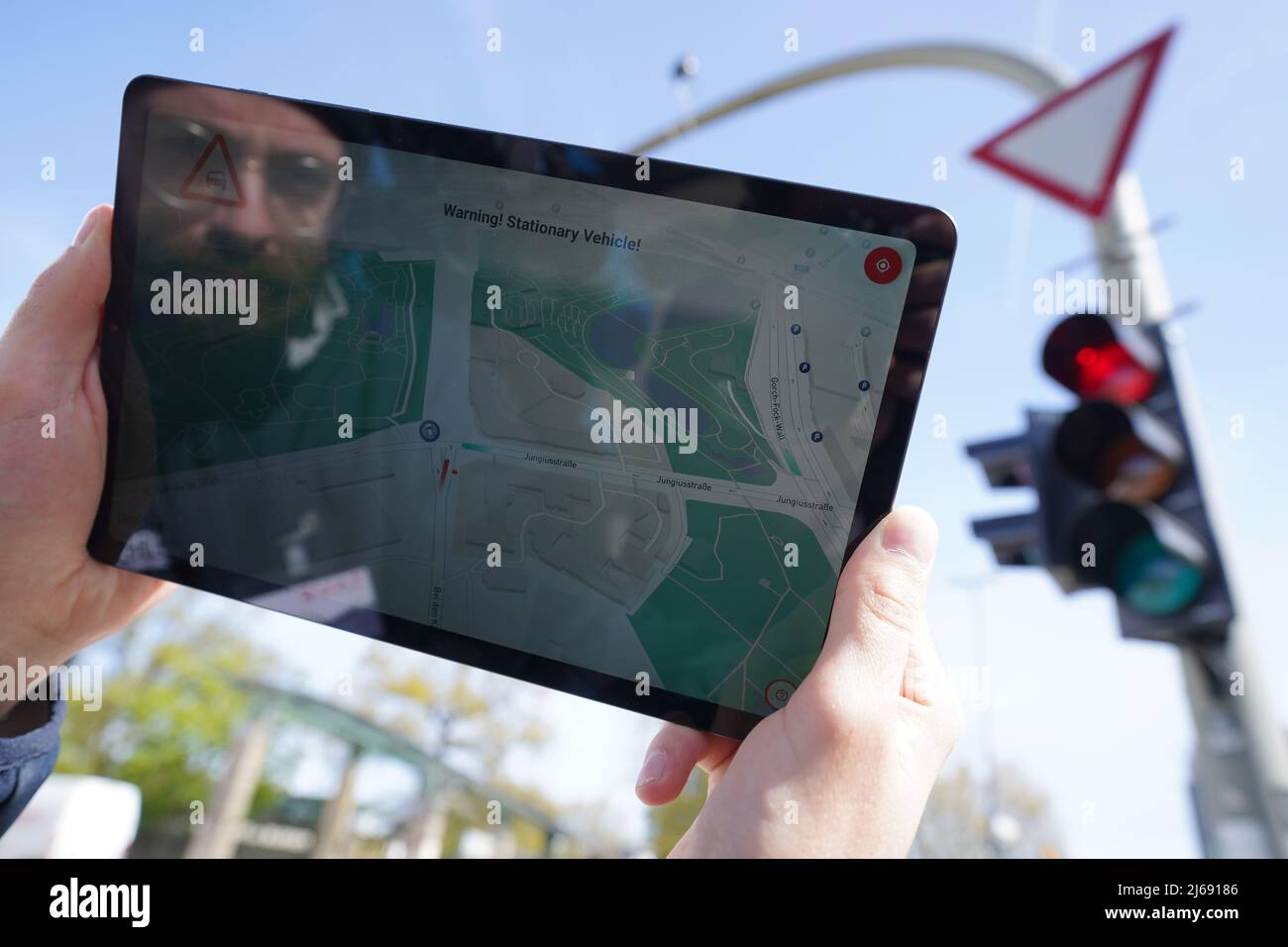 29 April 2022, Hamburg: An employee holds up a tablet with an ...