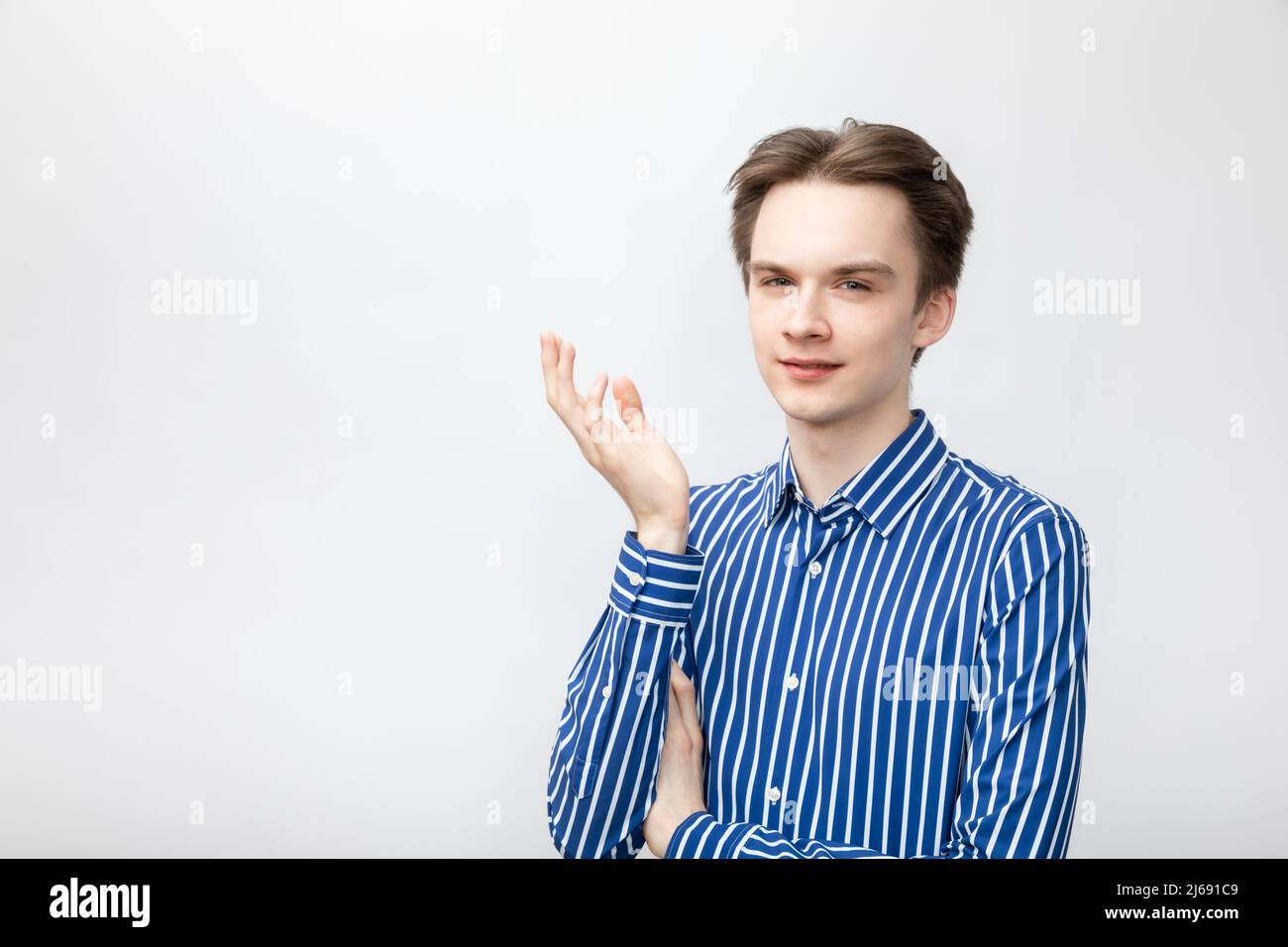 Portrait of doubtful young man wearing blue-white striped button shirt ...
