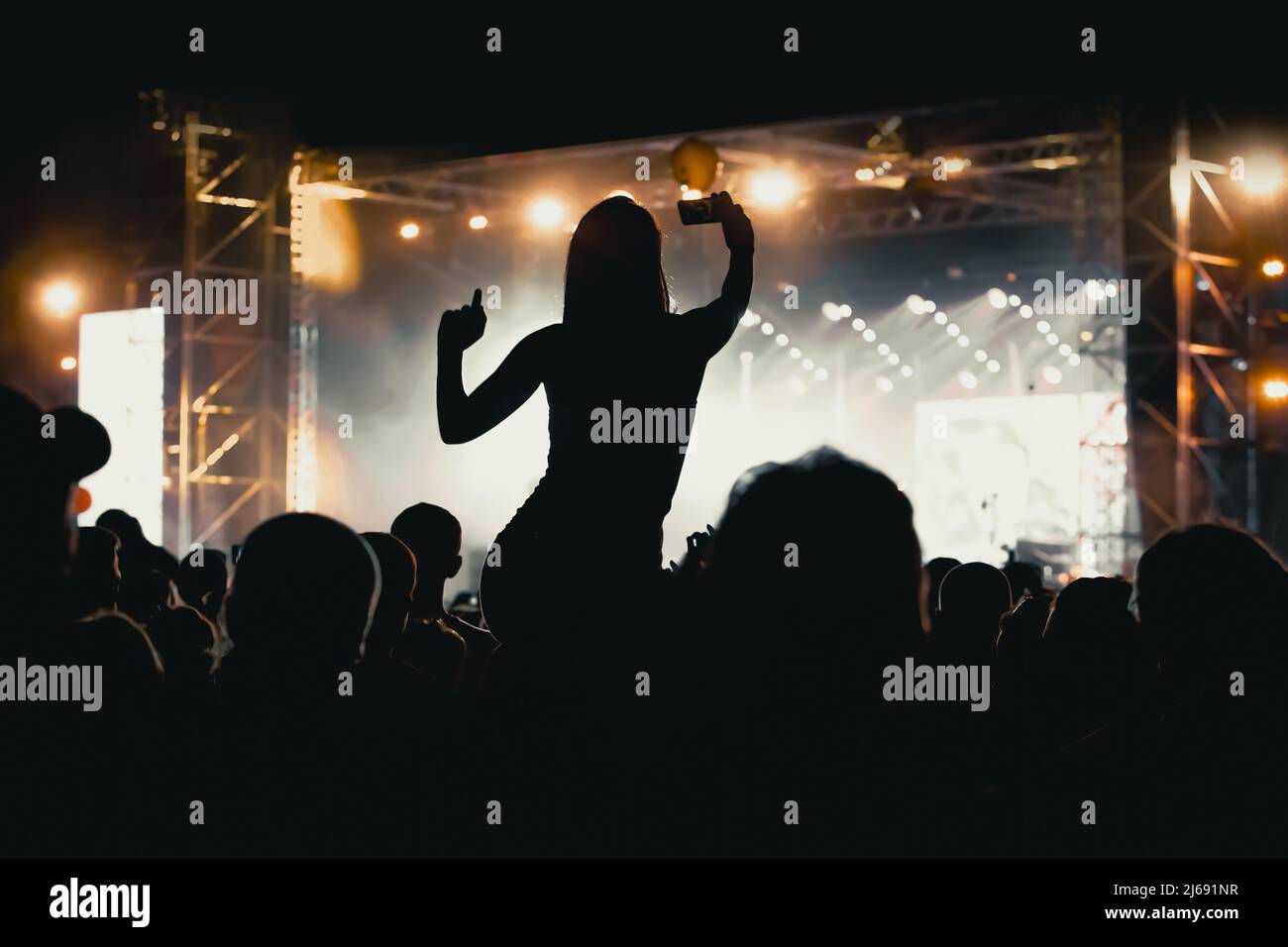 Girl on shoulders in the crowd at a music festival Stock Photo - Alamy